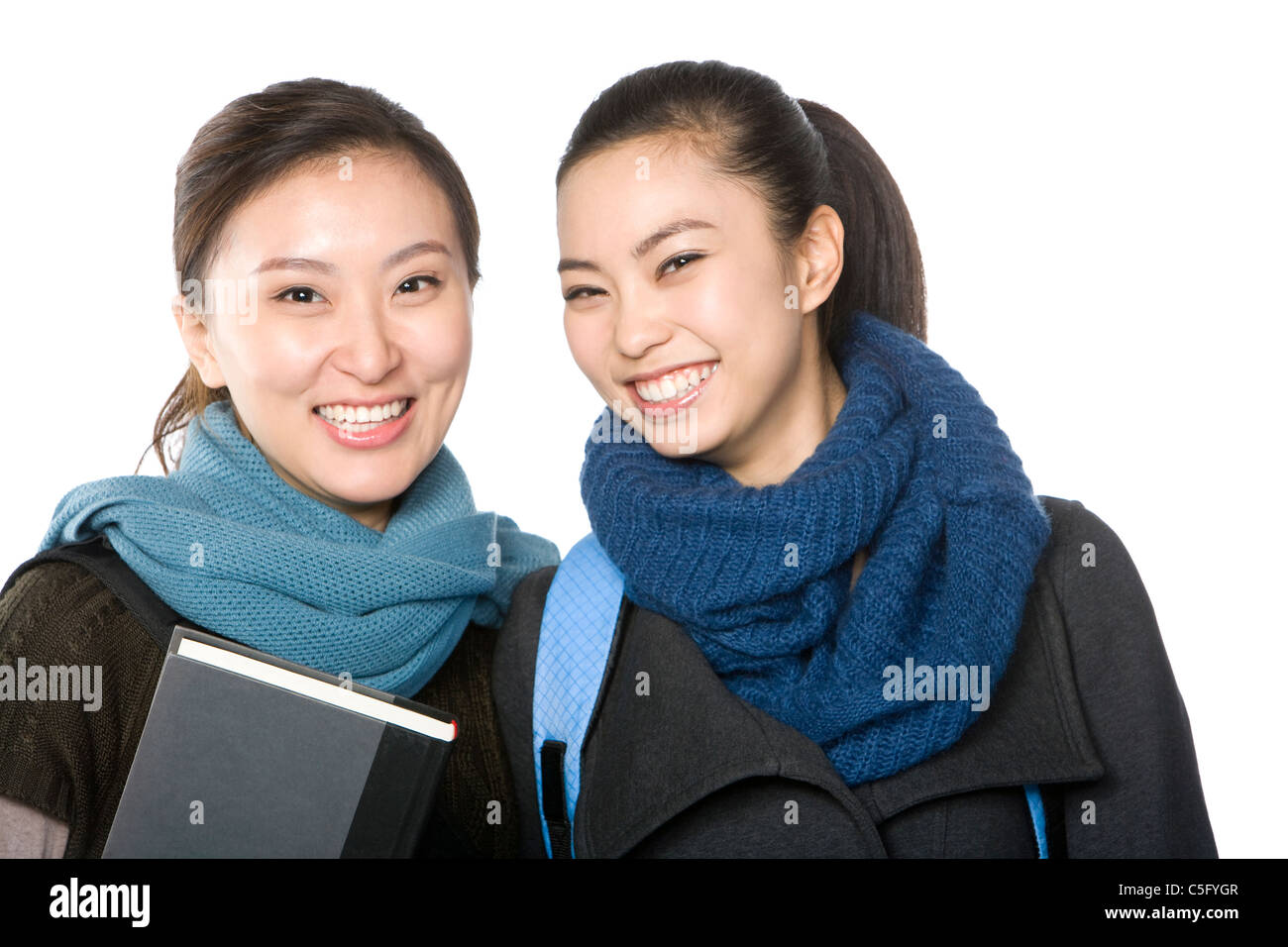 Two female classmates smiling, white background Stock Photo - Alamy