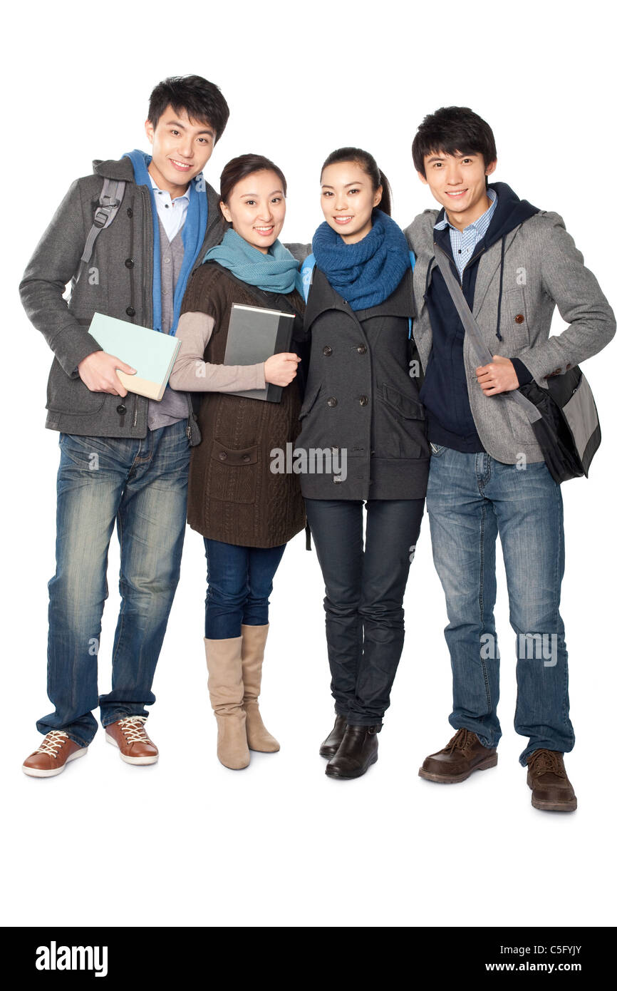 Four smiling classmates standing together, white background Stock Photo ...