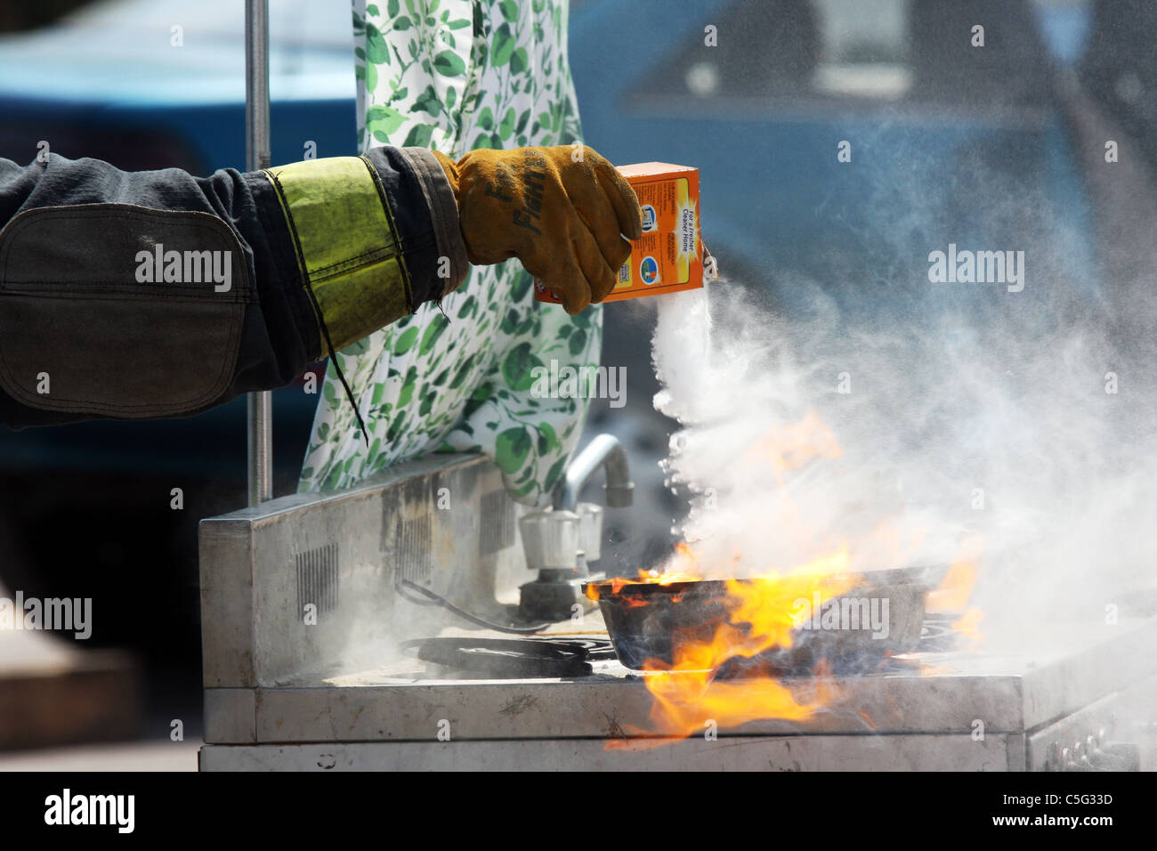 A stove top fire demonstration extinguished by a firefighter Stock ...