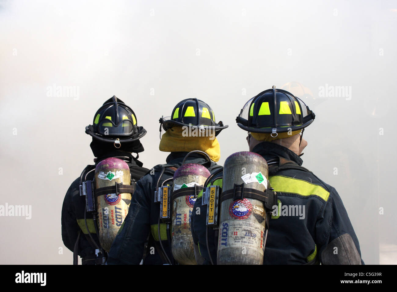 Three fire fighters surrounded by smoke Stock Photo - Alamy