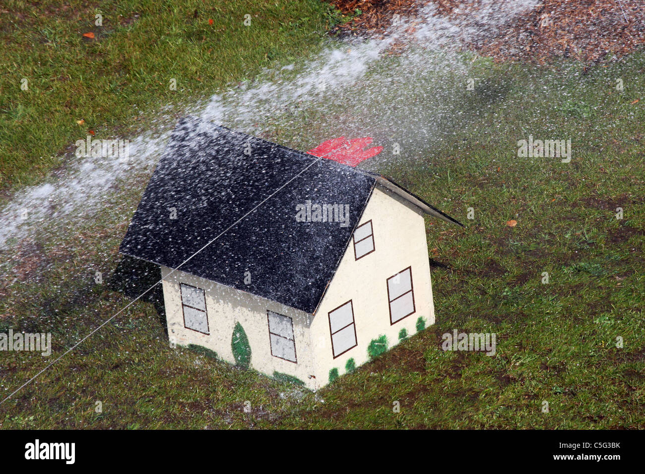 Spray of water from a hose line dousing a wooden flame representing a ...