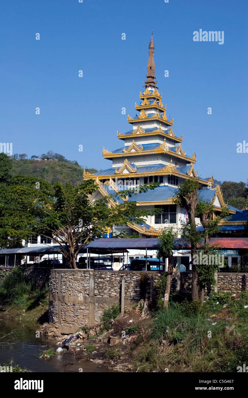 A Burmese style Buddhist temple overlooks a dirty and polluted river in ...
