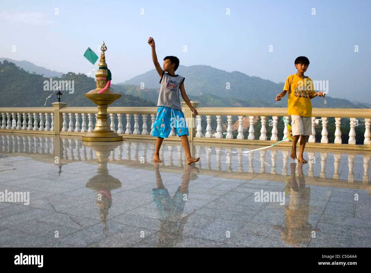 Young boys are flying kites on an observation deck that overlooks Burma ...