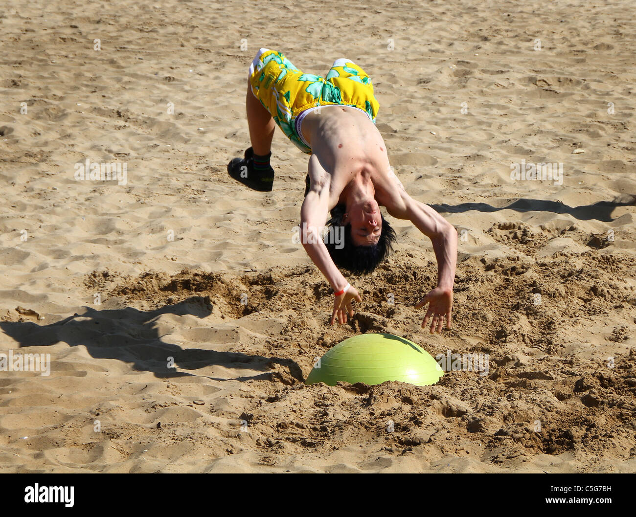 Youth doing somersault on beach Stock Photo - Alamy