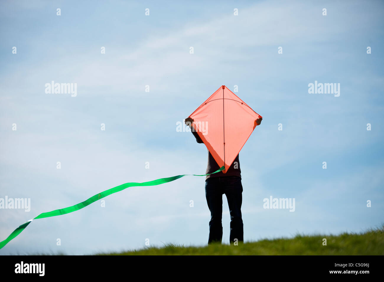 A man holding a red kite Stock Photo - Alamy