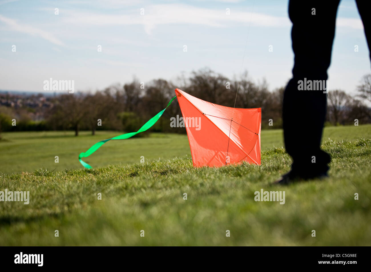 A red kite lying at someone's feet, close-up Stock Photo - Alamy