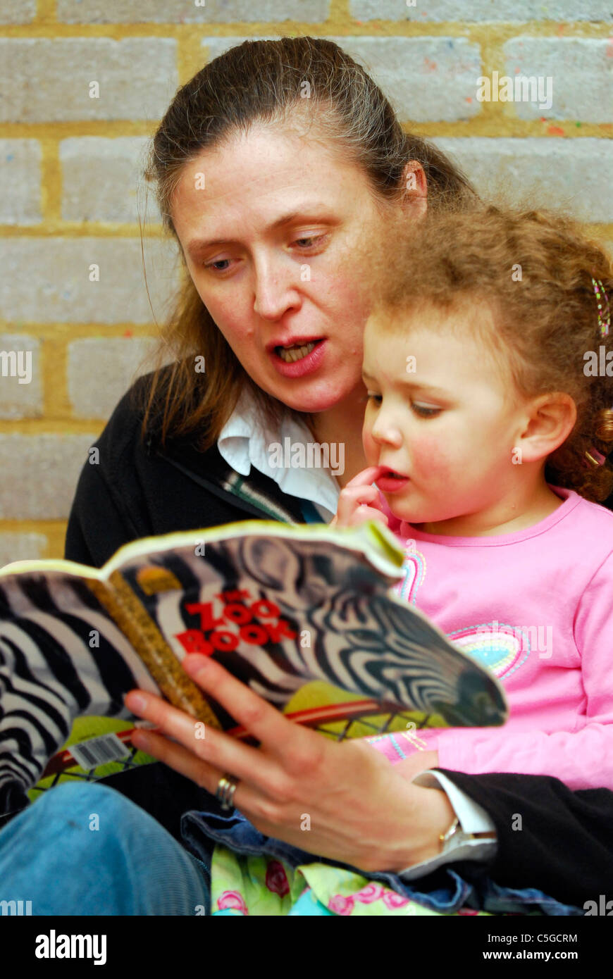 Mother reading to child in creche, Surrey, UK Stock Photo - Alamy