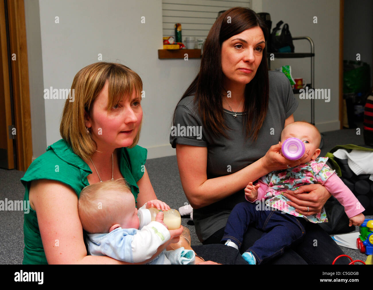 Mother bottle feeding baby in creche, Surrey, UK Stock Photo - Alamy