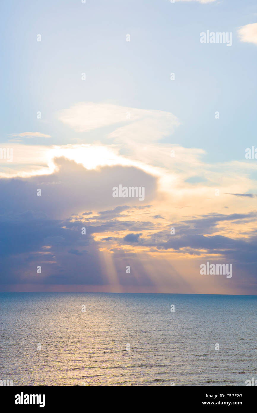 Beams of sun light break through cloud over the sea Stock Photo - Alamy
