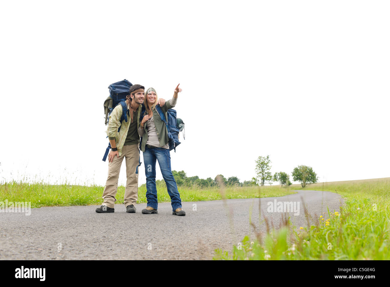 Hiking young couple backpack tramping on asphalt road countryside Stock ...