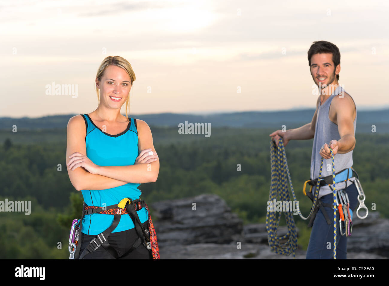 Active young couple rock climbing reach top at sunset Stock Photo - Alamy