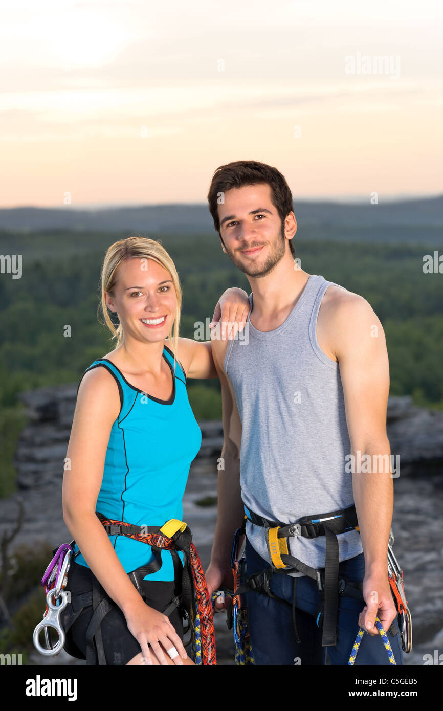 Active young couple rock climbing reach top at sunset Stock Photo - Alamy