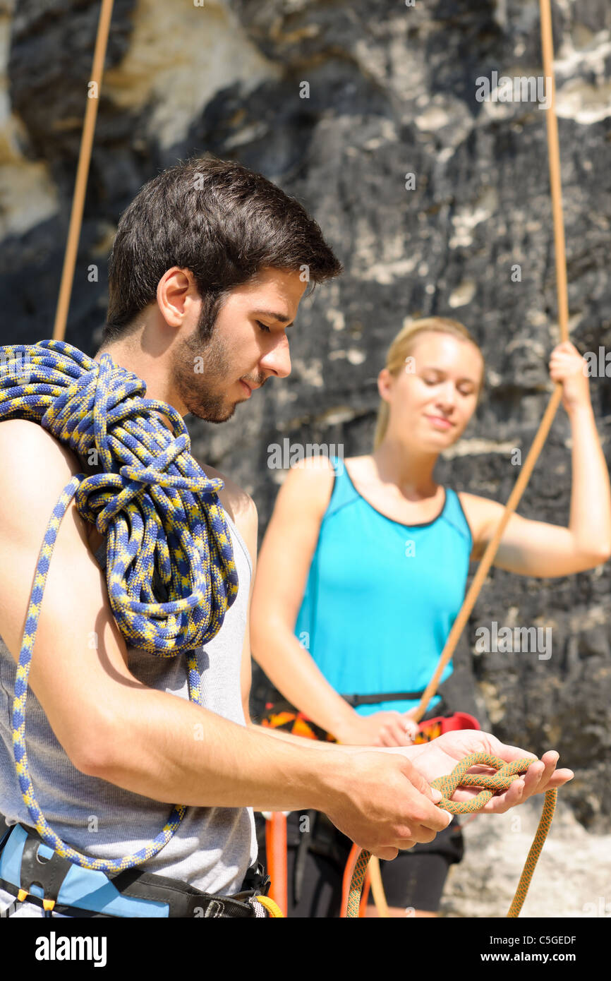 Rock climbing active young man showing mountaineer woman rope knot ...