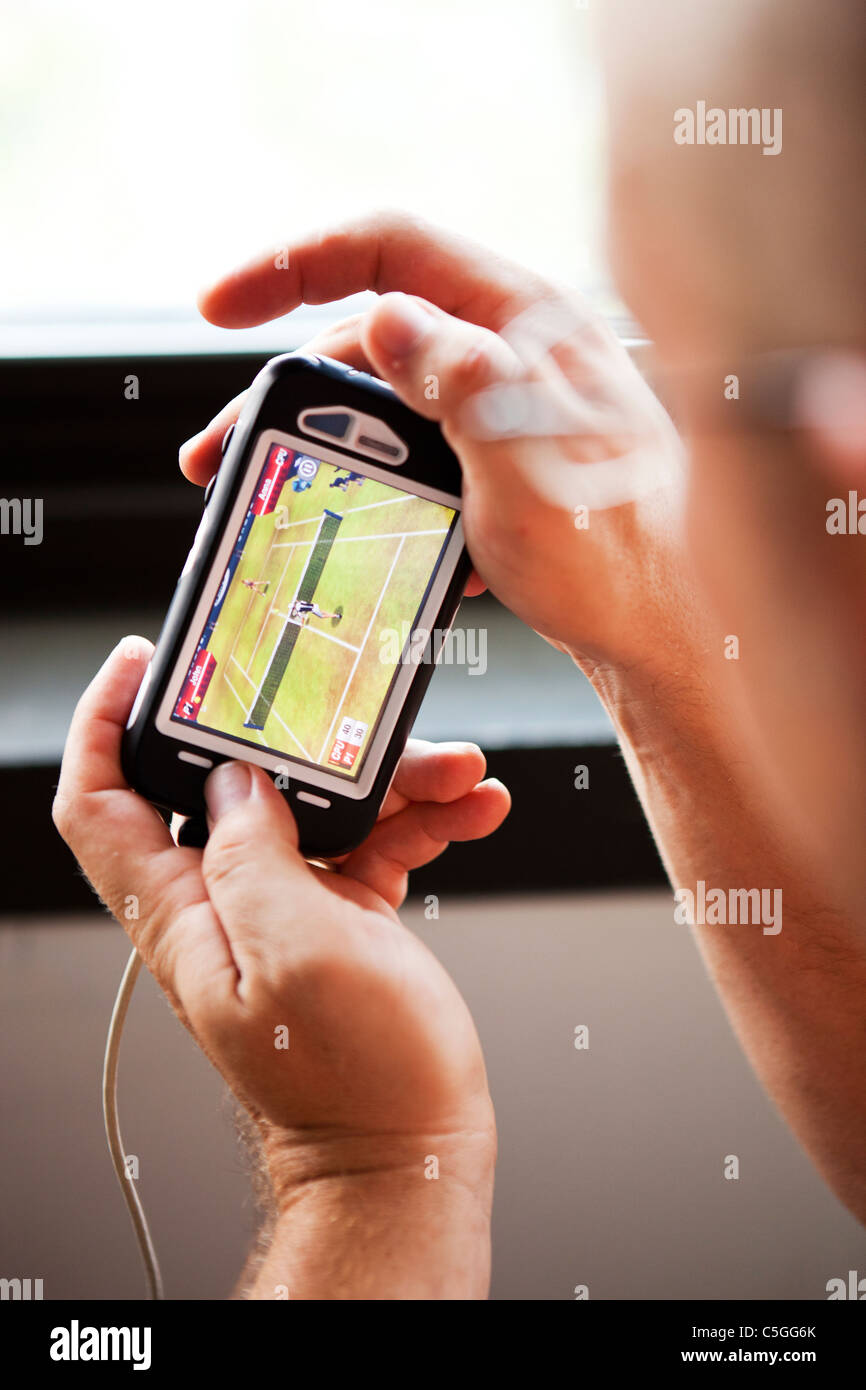 man playing game on iphone Stock Photo - Alamy