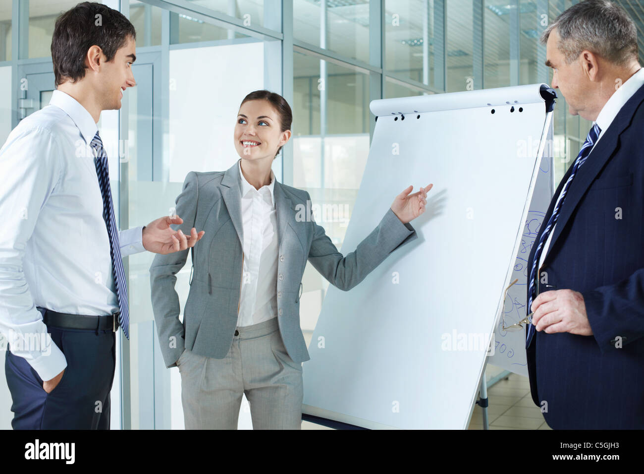 Young woman presenting project to her colleagues Stock Photo - Alamy