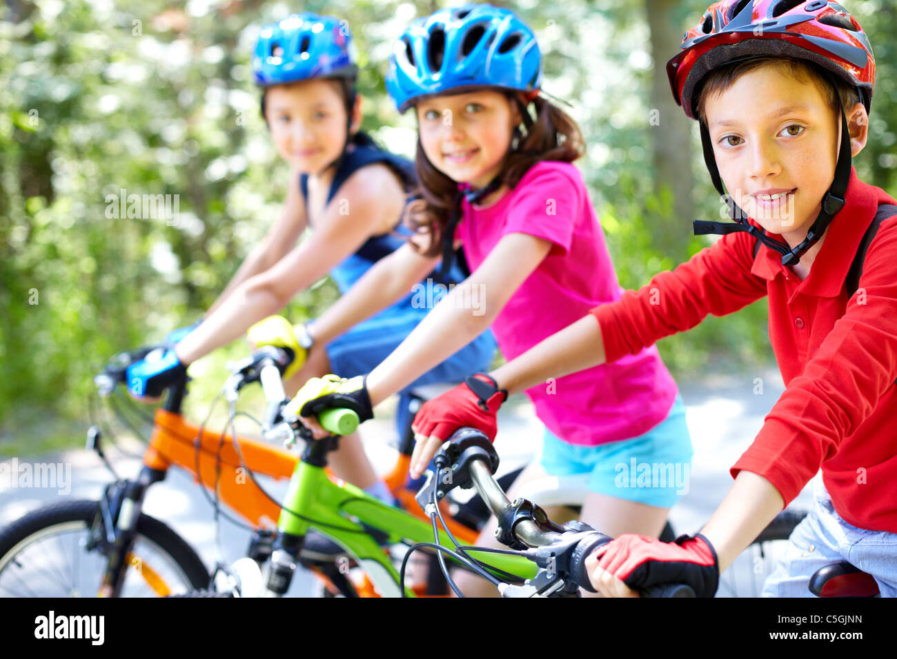 Three little children riding their bikes Stock Photo - Alamy