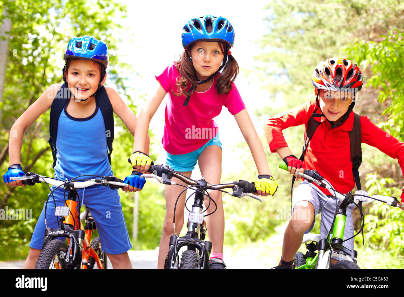 Portrait of three little cyclists riding their bikes Stock Photo - Alamy