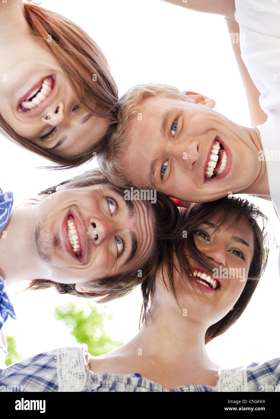 Circle of happy friends with their heads together Stock Photo - Alamy