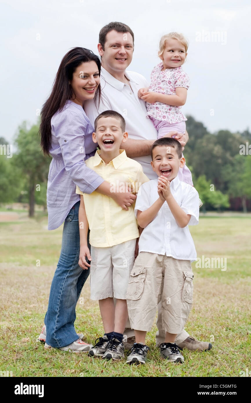 Happy family posing together with smile in the park on natural ...