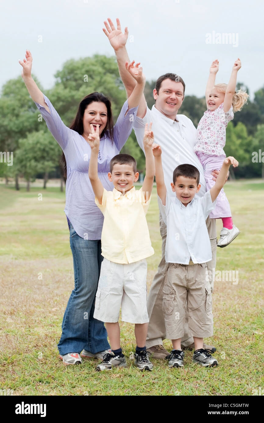 Happy family enjoying by raising hands on natural background and ...