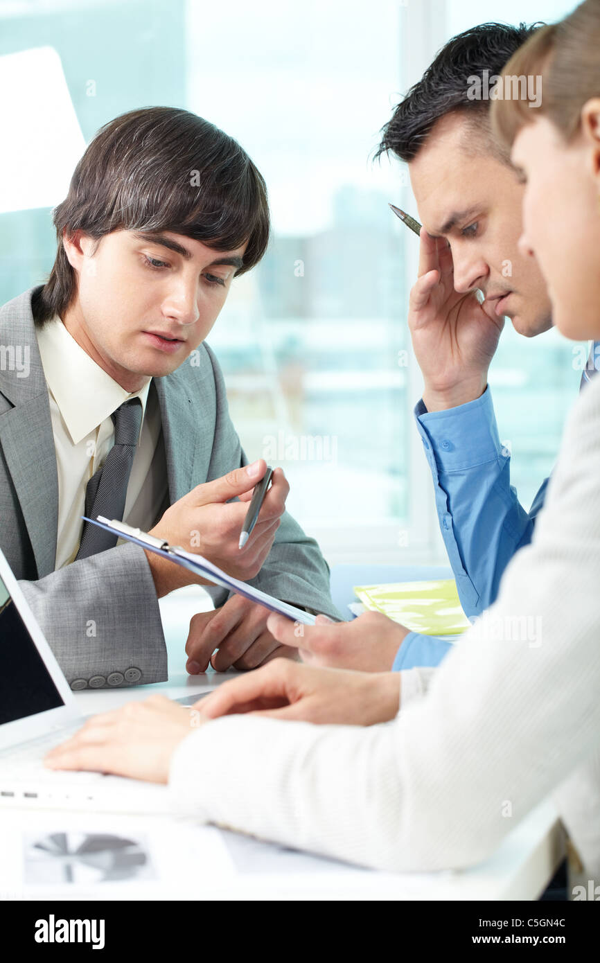 Three business people thinking together over a task Stock Photo - Alamy