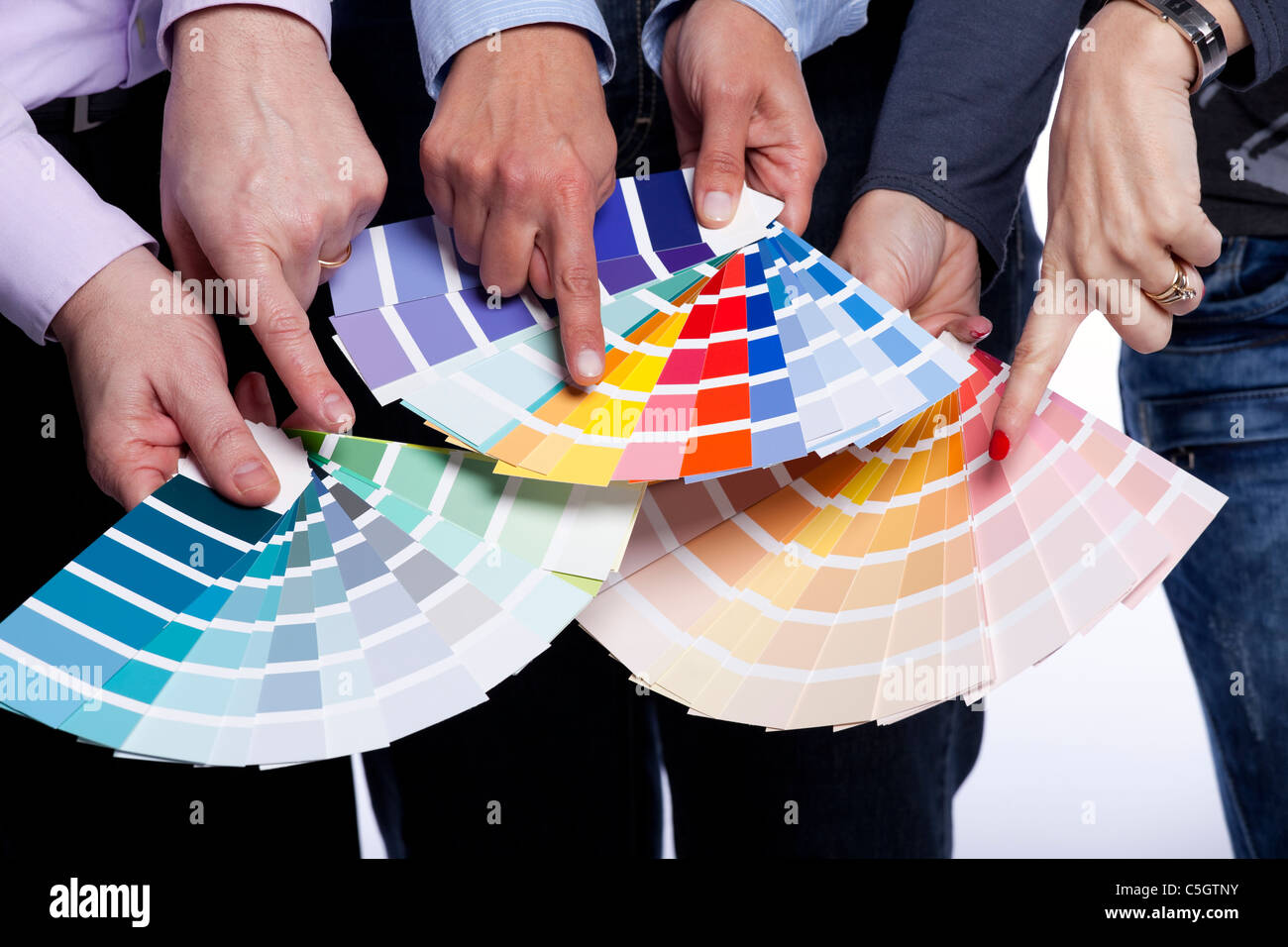 Group of people hands pointing to color samples in palette pantone ...