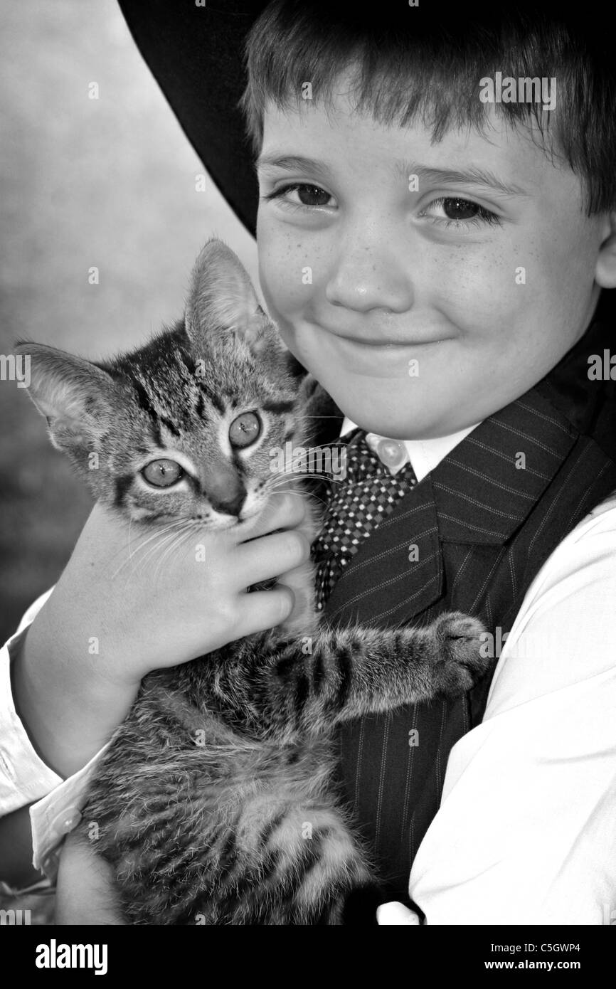 A young cowboy holding a farm cat focus on the boys eyes Stock Photo ...