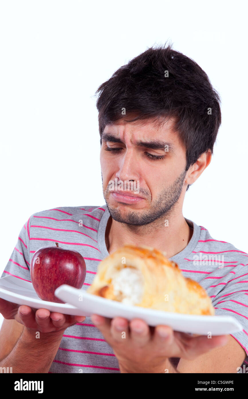 man thinking what to eat between an apple and a cake (isolated on white ...
