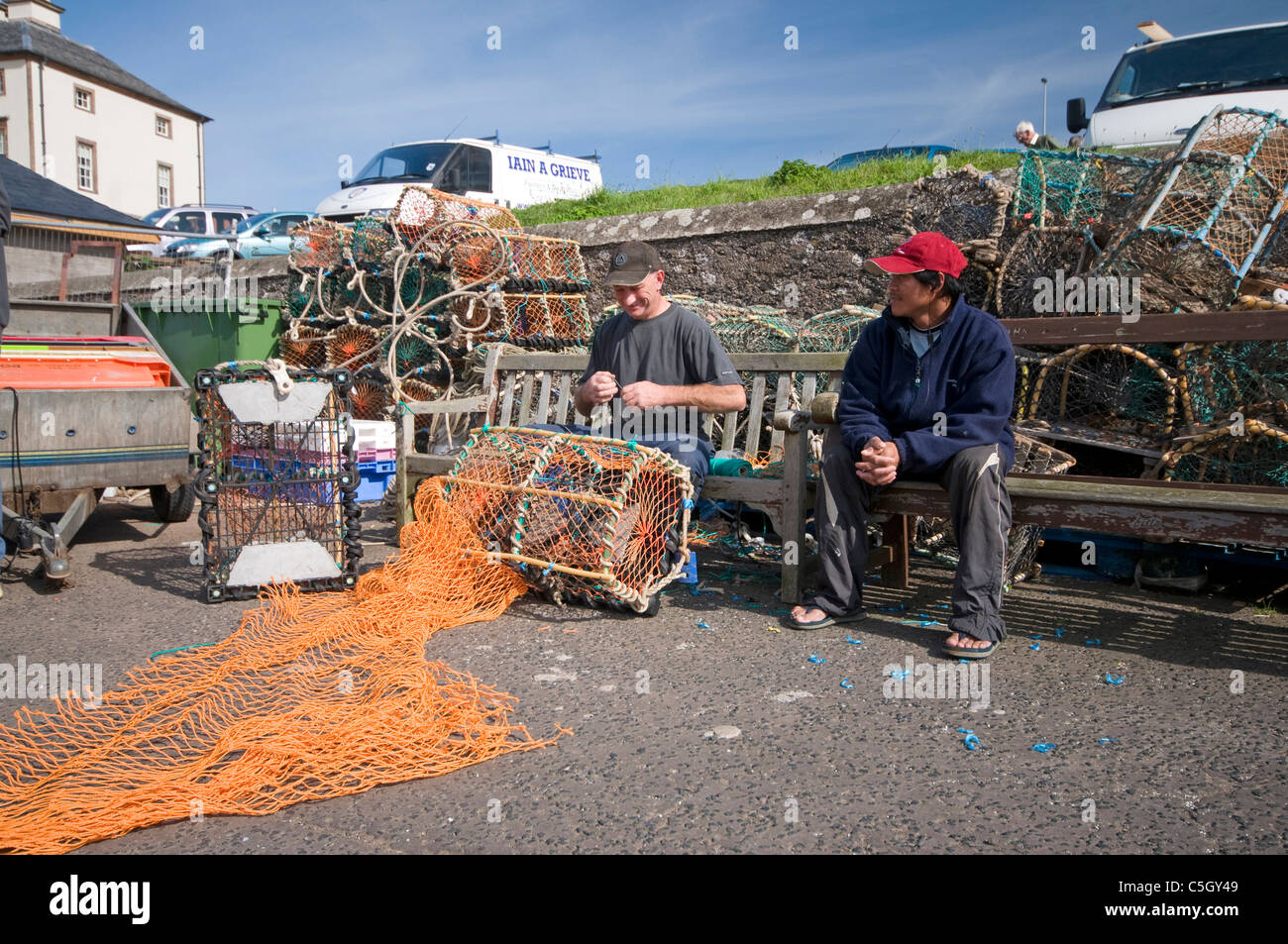 Fishermen mending nets on the harbourside at Eyemouth Stock Photo - Alamy