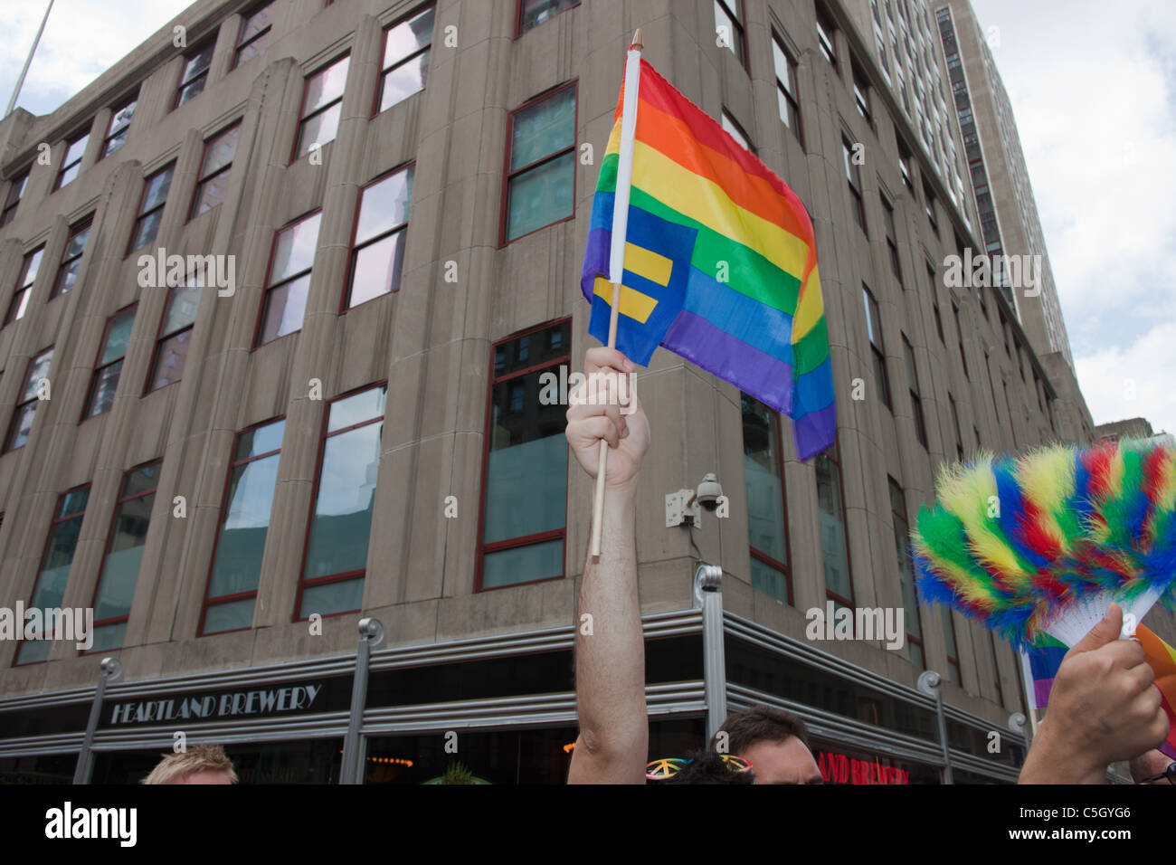 The gay pride rainbow flag is held up under the Empire State Building ...