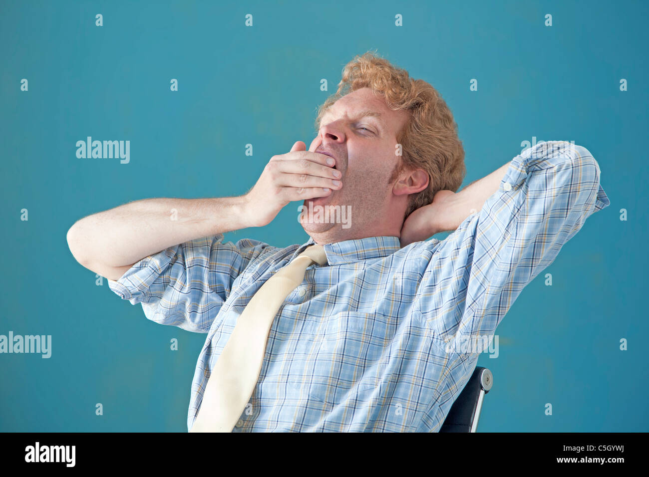 man yawning while sitting Stock Photo - Alamy