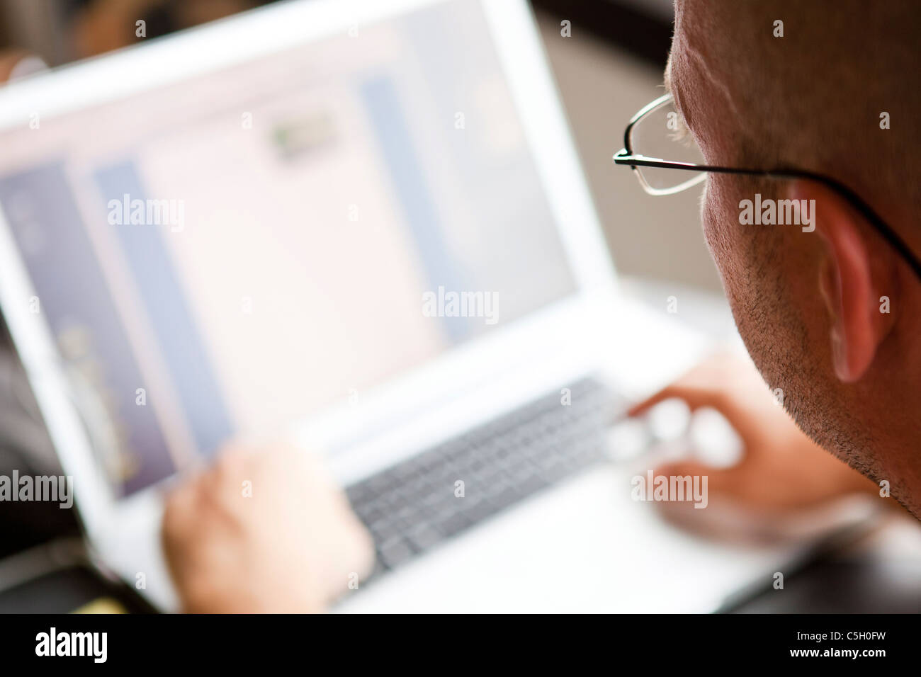 Man using a laptop indoors Stock Photo - Alamy