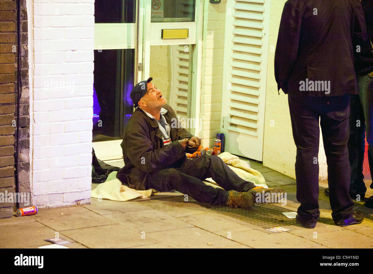 people-talking-to-an-old-man-sat-in-a-doorway-at-night-stock-photo-alamy