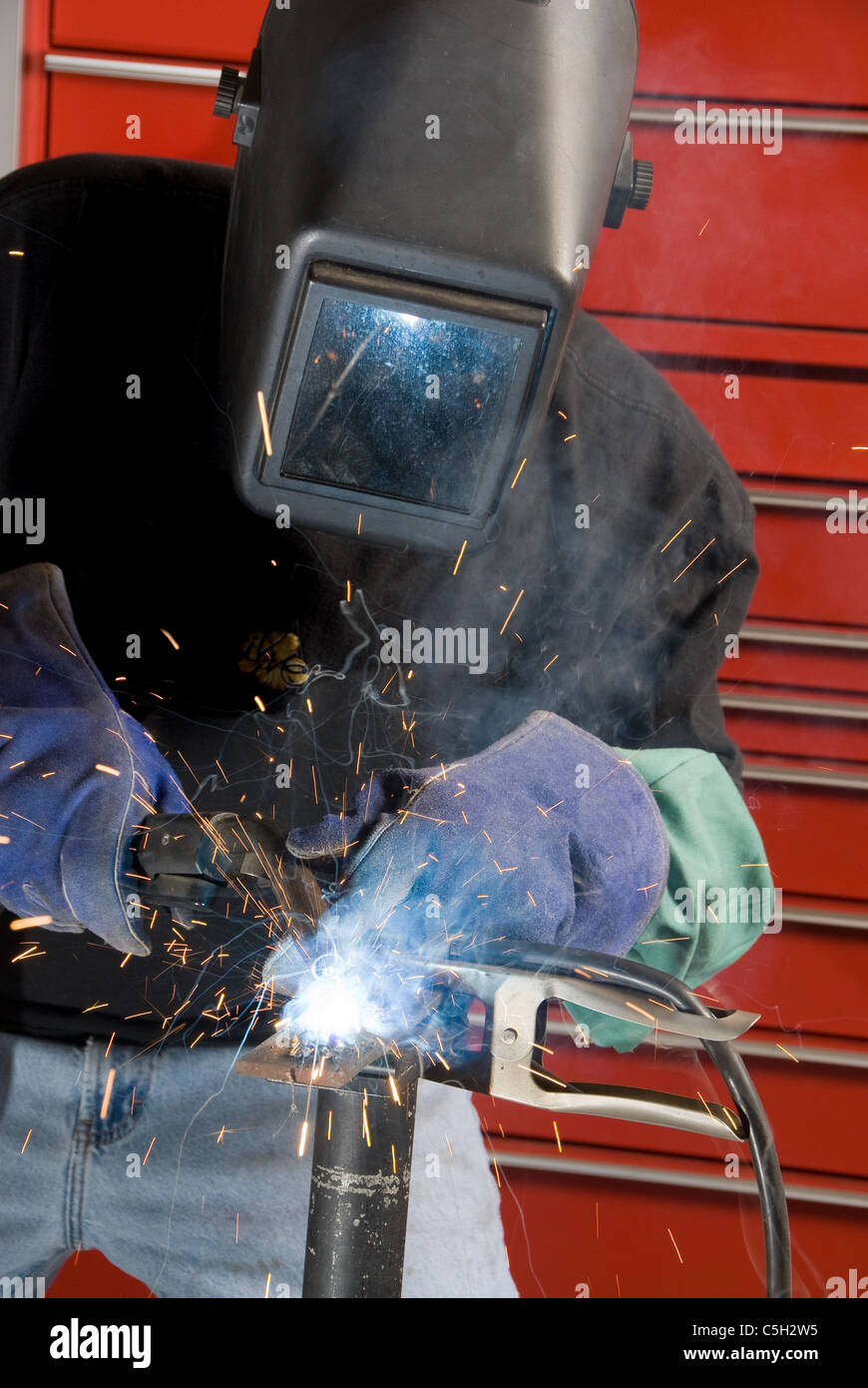 A welder fabricates a tool by attaching two pieces of metal Stock Photo ...