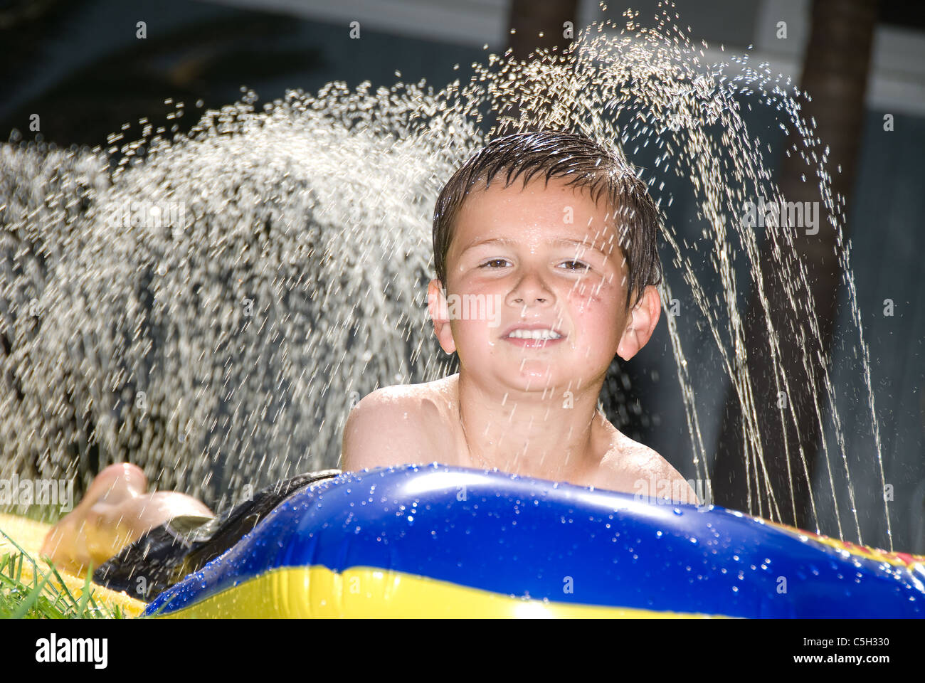 A kid slides down a slippery water slider during a hot summer day Stock ...