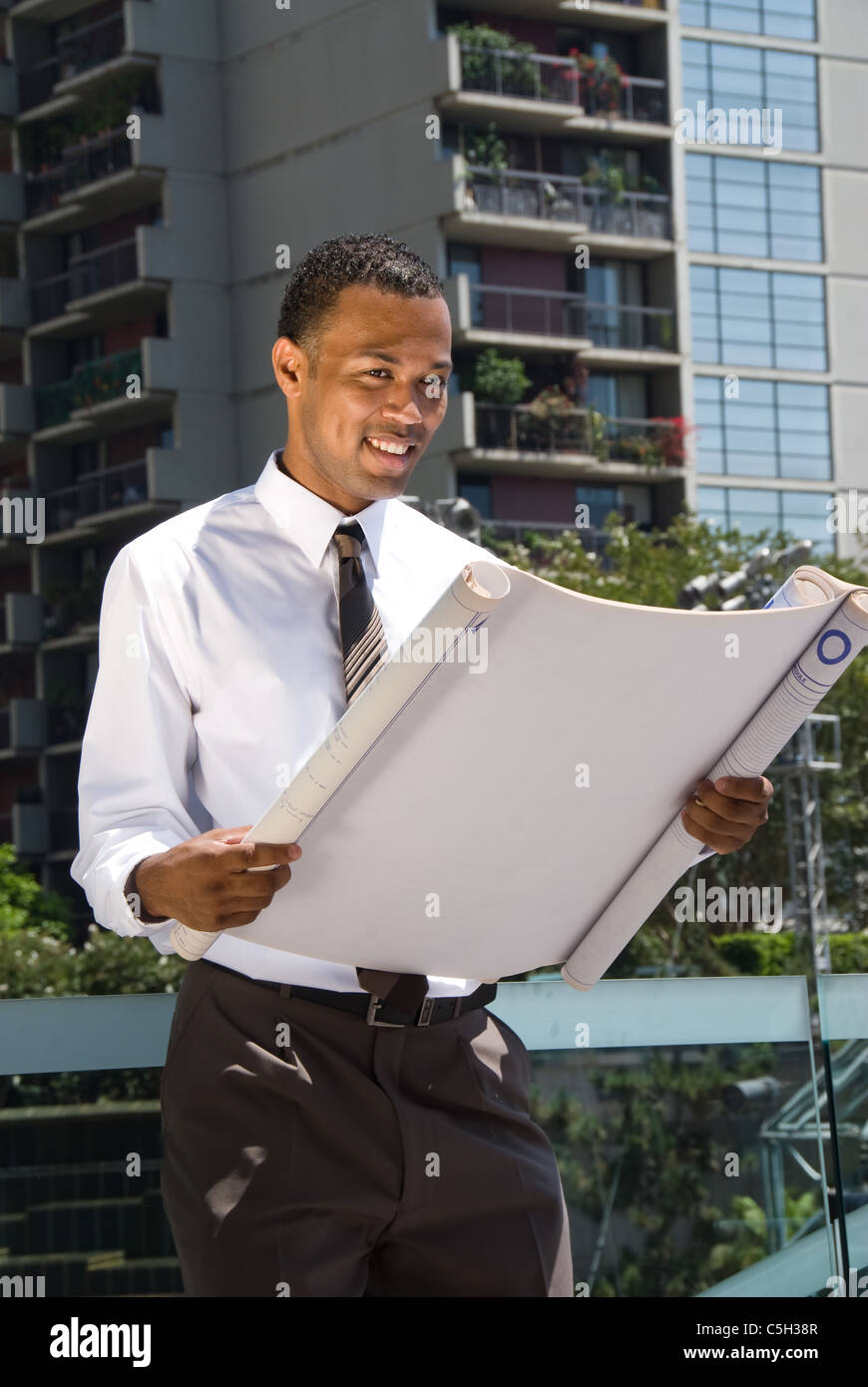 A male African American architect executive reviews specifications for ...