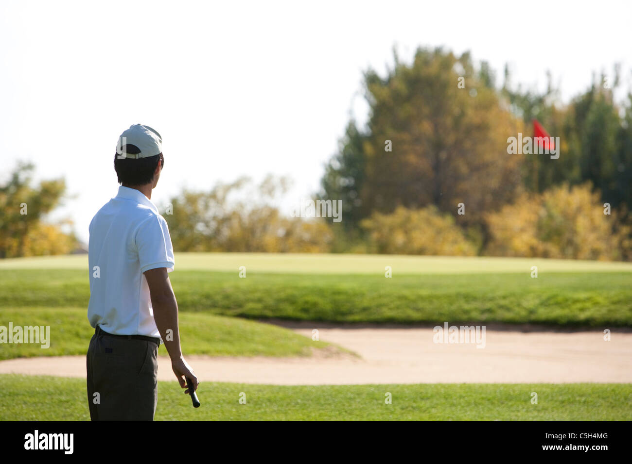 Young Man Watching Golf Ball Stock Photo - Alamy