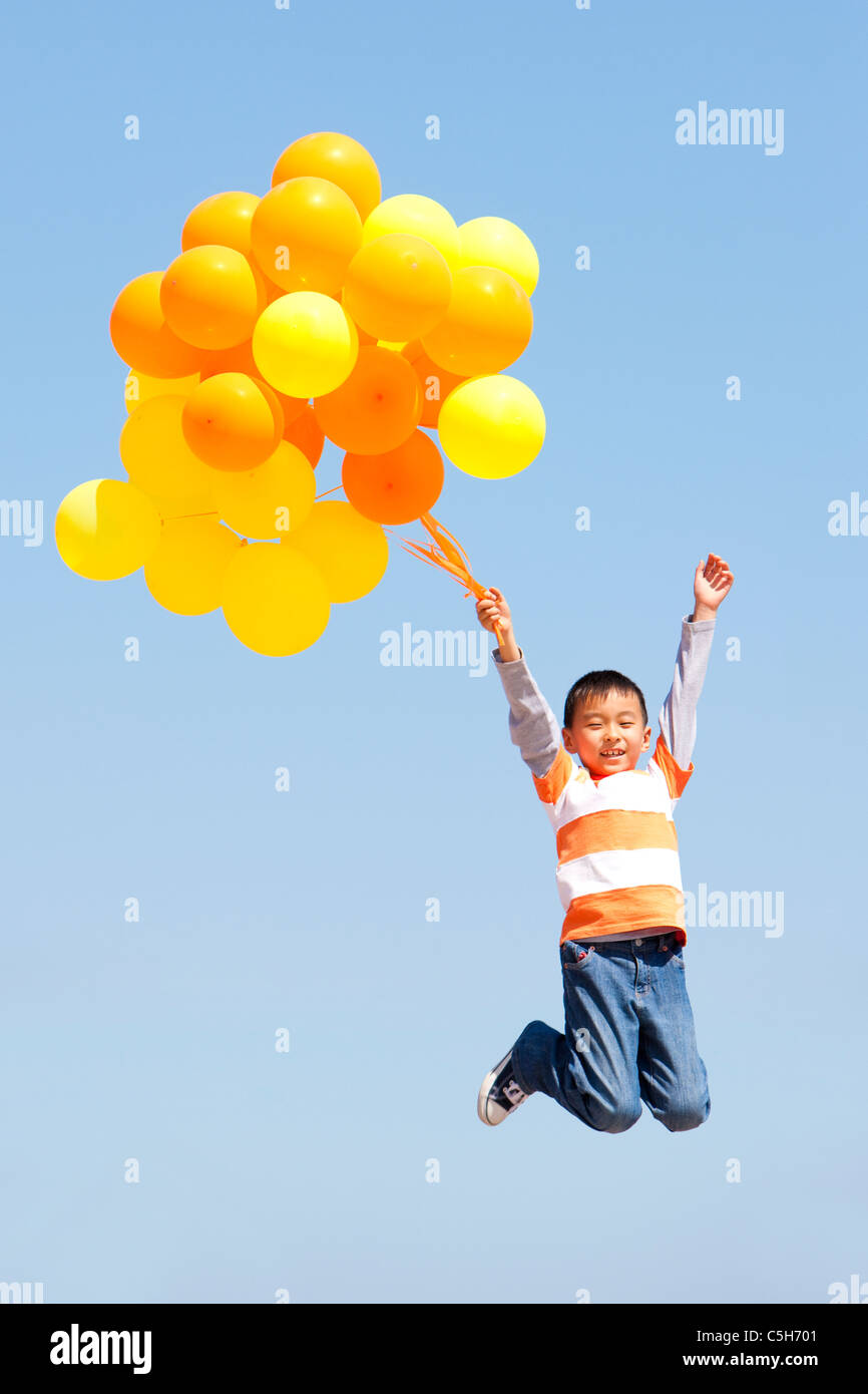 Young Boy Jumping with Balloons Stock Photo - Alamy