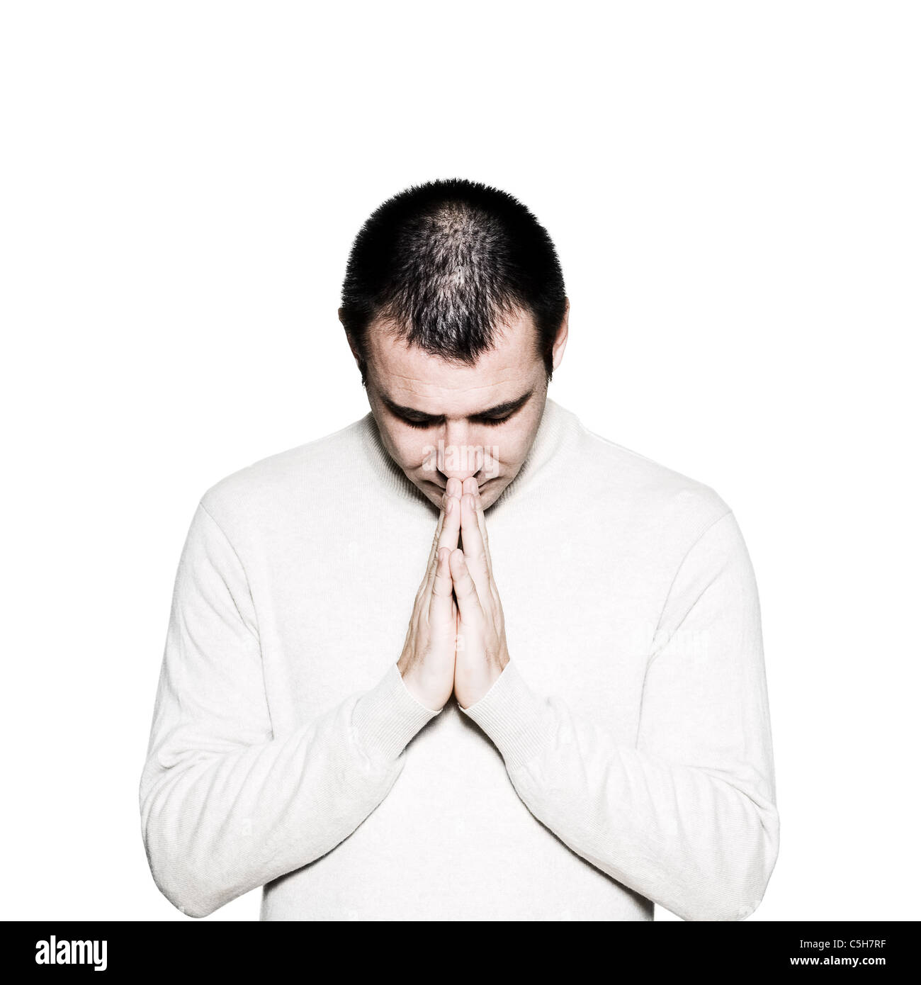 Portrait of a handsome expressive religious man praying in studio on ...