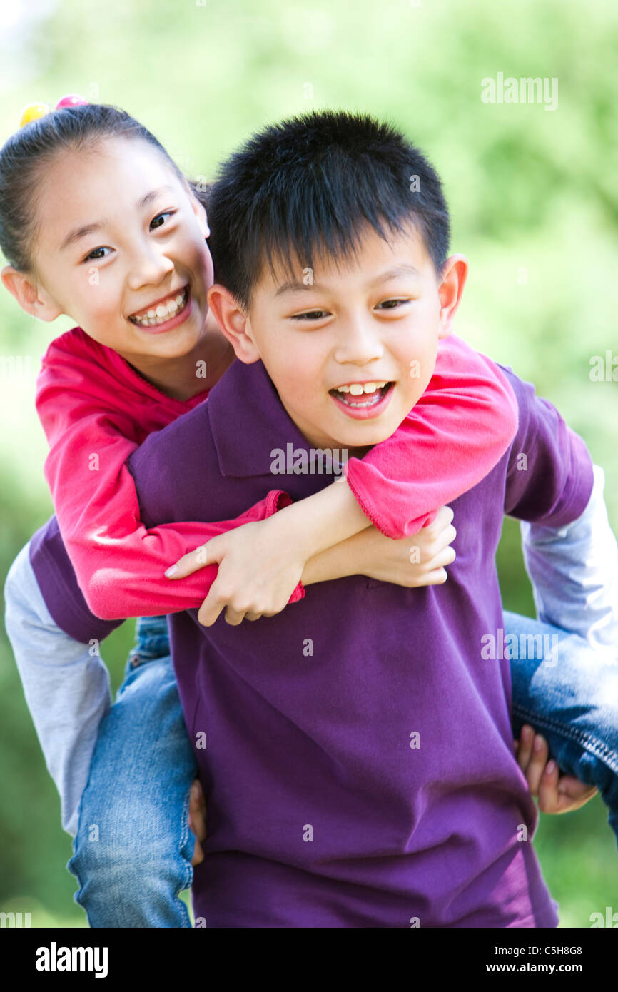 Young boy giving girl piggyback ride Stock Photo - Alamy