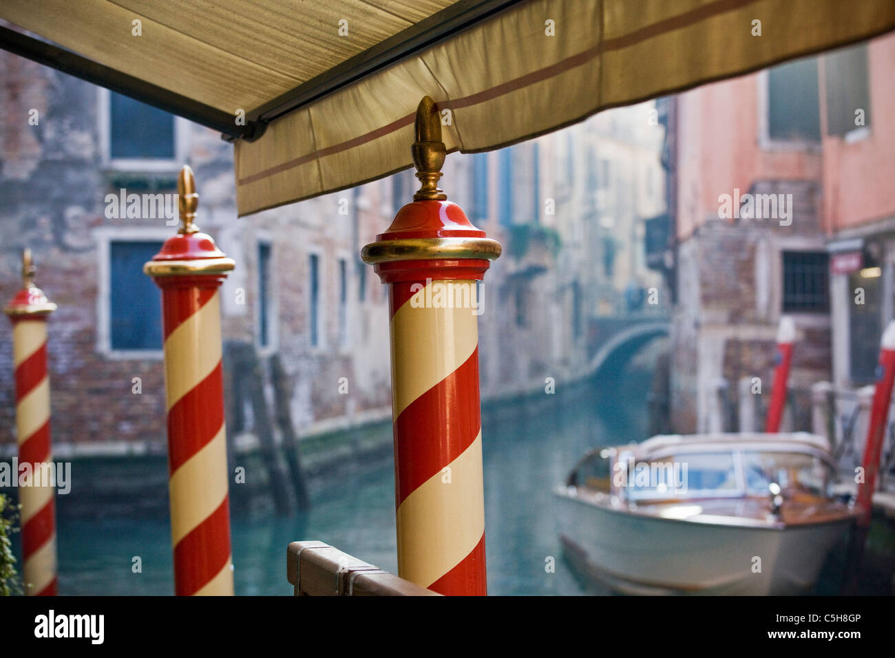 Striped mooring posts by a canal, Venice, Italy Stock Photo - Alamy