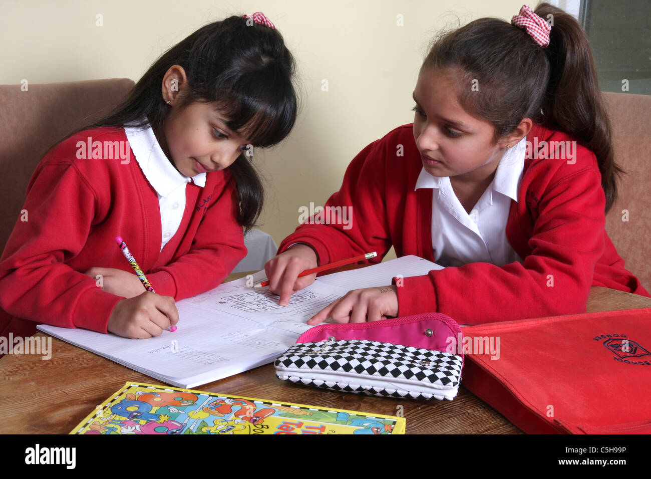 Two sisters doing their homework at home Stock Photo - Alamy