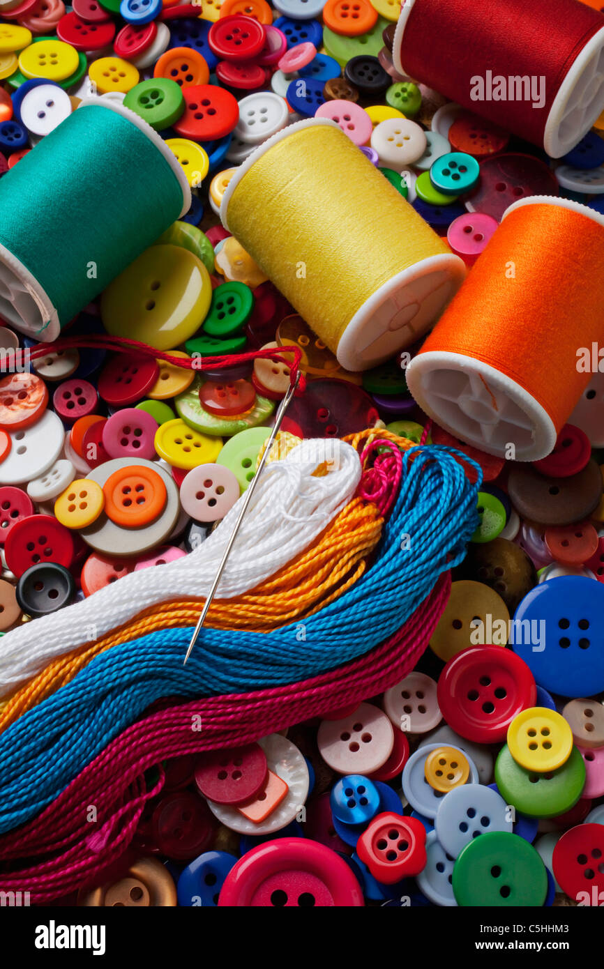 Spools of thread and buttons with needle Stock Photo - Alamy