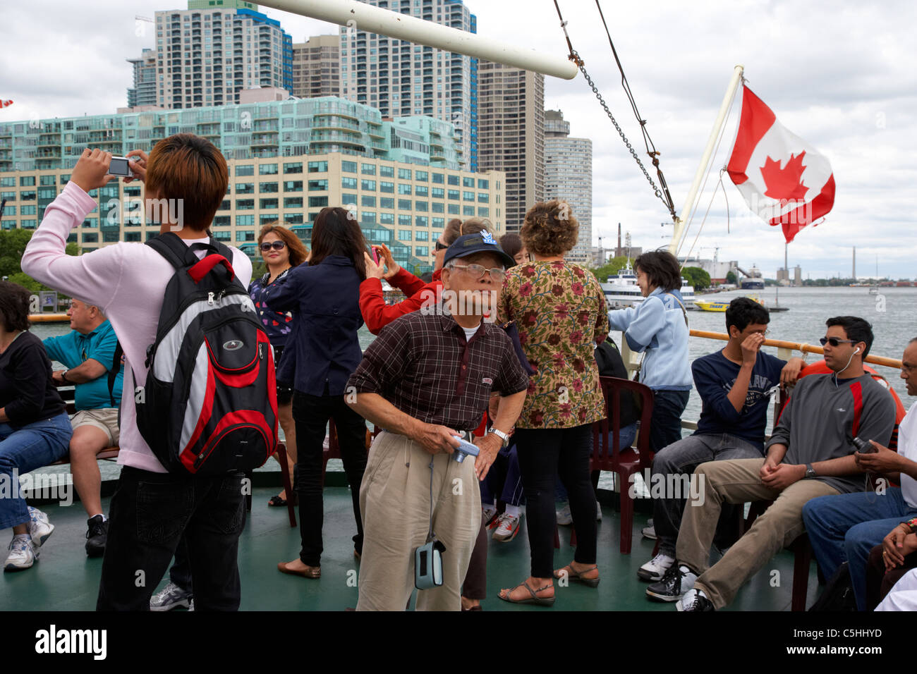 asian tourists taking photos on board toronto harbour cruise on lake ...