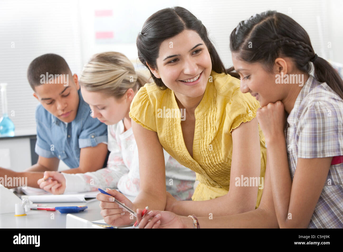 Teacher helping pupil Stock Photo - Alamy