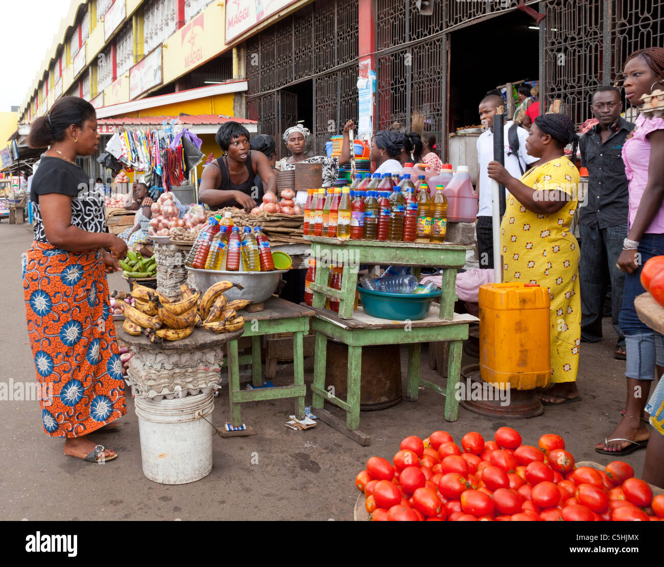 Market traders selling a range of fresh food produce and cooking ...