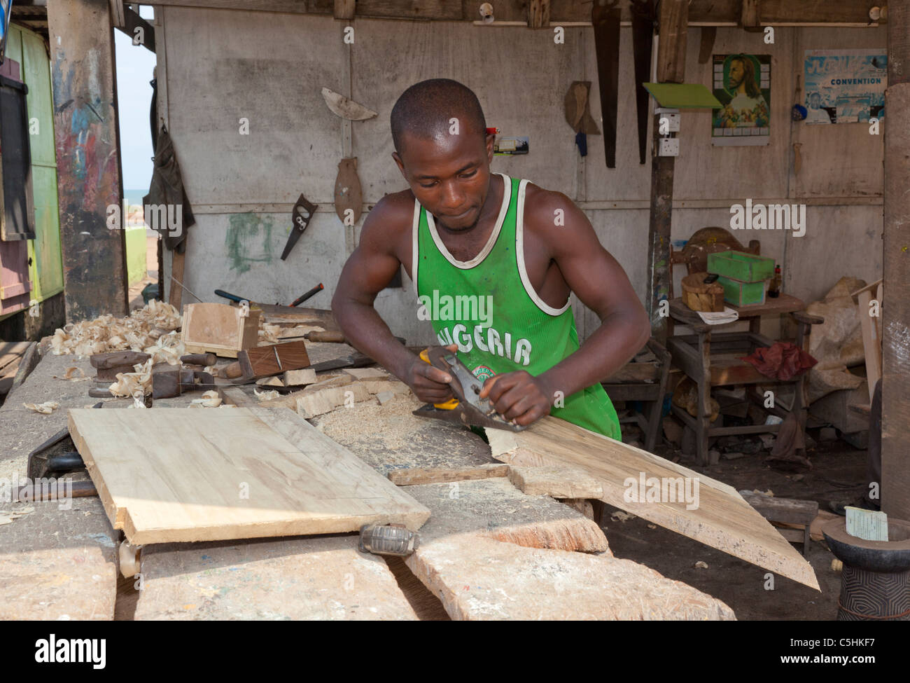 A carpenter planning a piece of timber to construct a coffin. Accra ...
