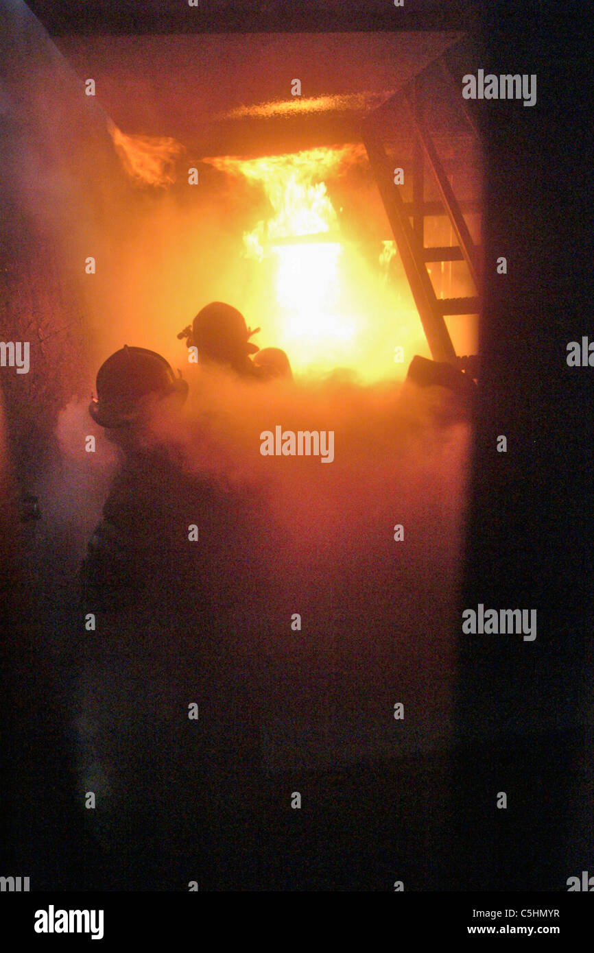Firefighters surrounded by smoke attack a kitchen fire inside the fire ...