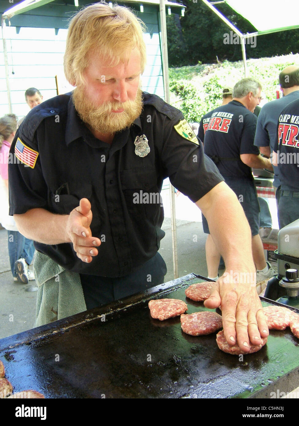 A volunteeer fire fighter cooks sausage patties for the Camp Meeker ...