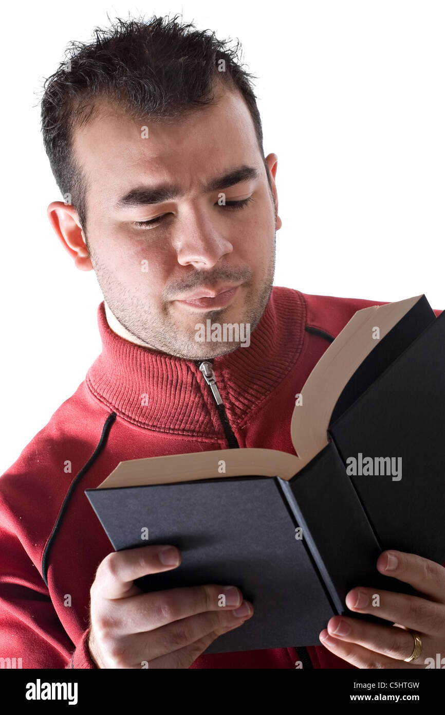 A young man reading a book with a serious expression on his face Stock ...